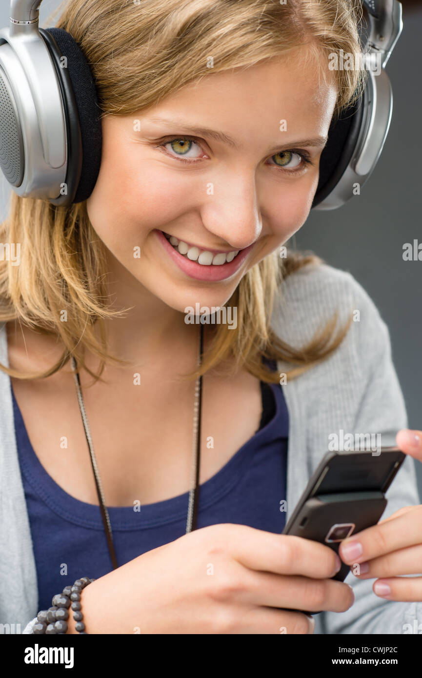 Teenage girl checking her mobile phone smiling looking at camera Stock ...