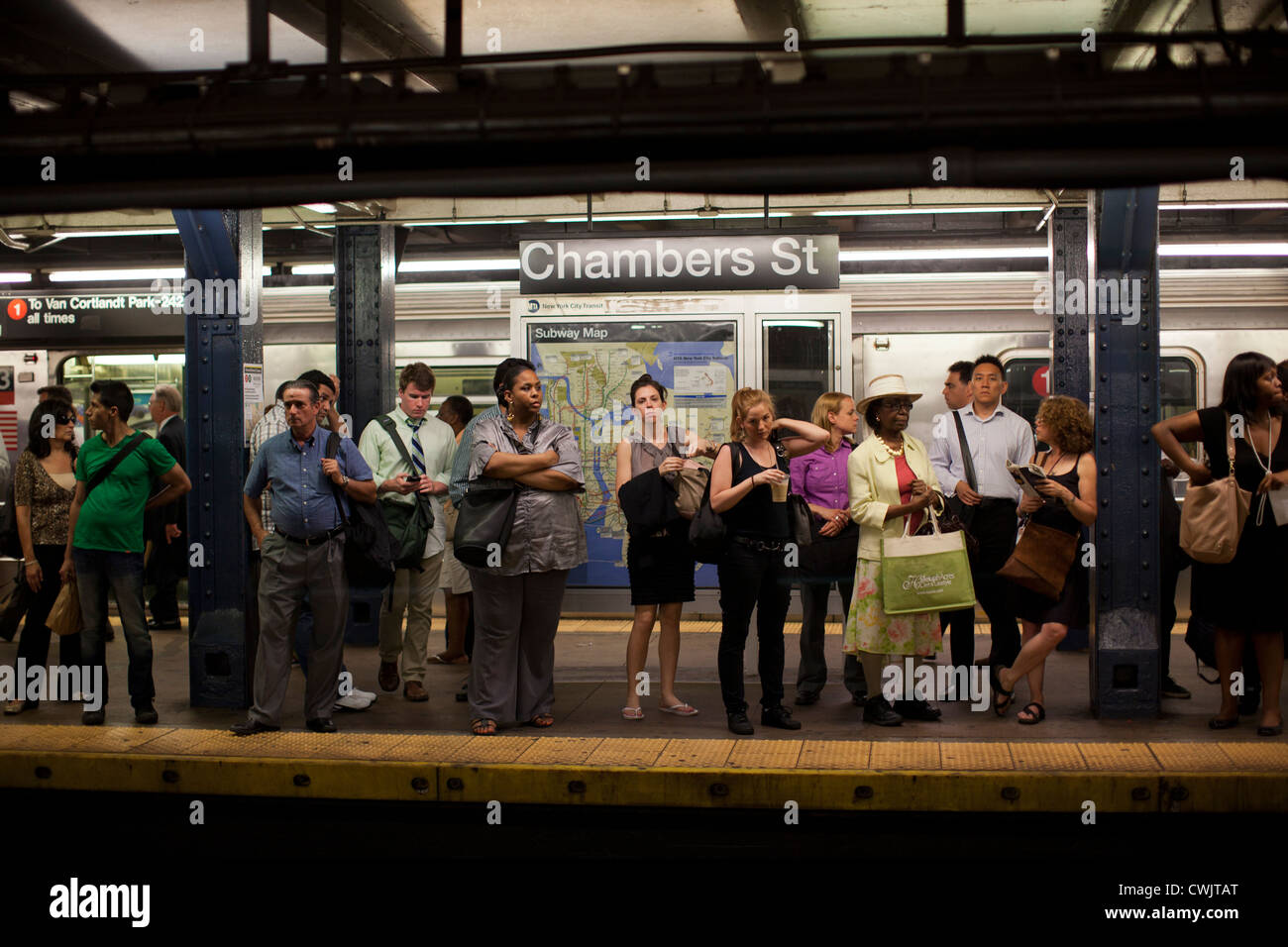 People stand on a lower Manhattan subway platform at the end of the day ...