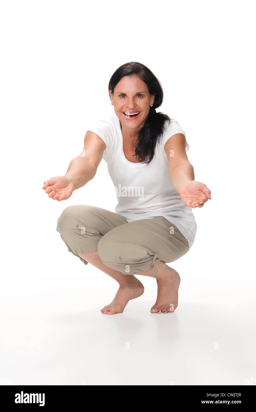 A portrait of an attractive, cheerful mom kneeling down with arms ...