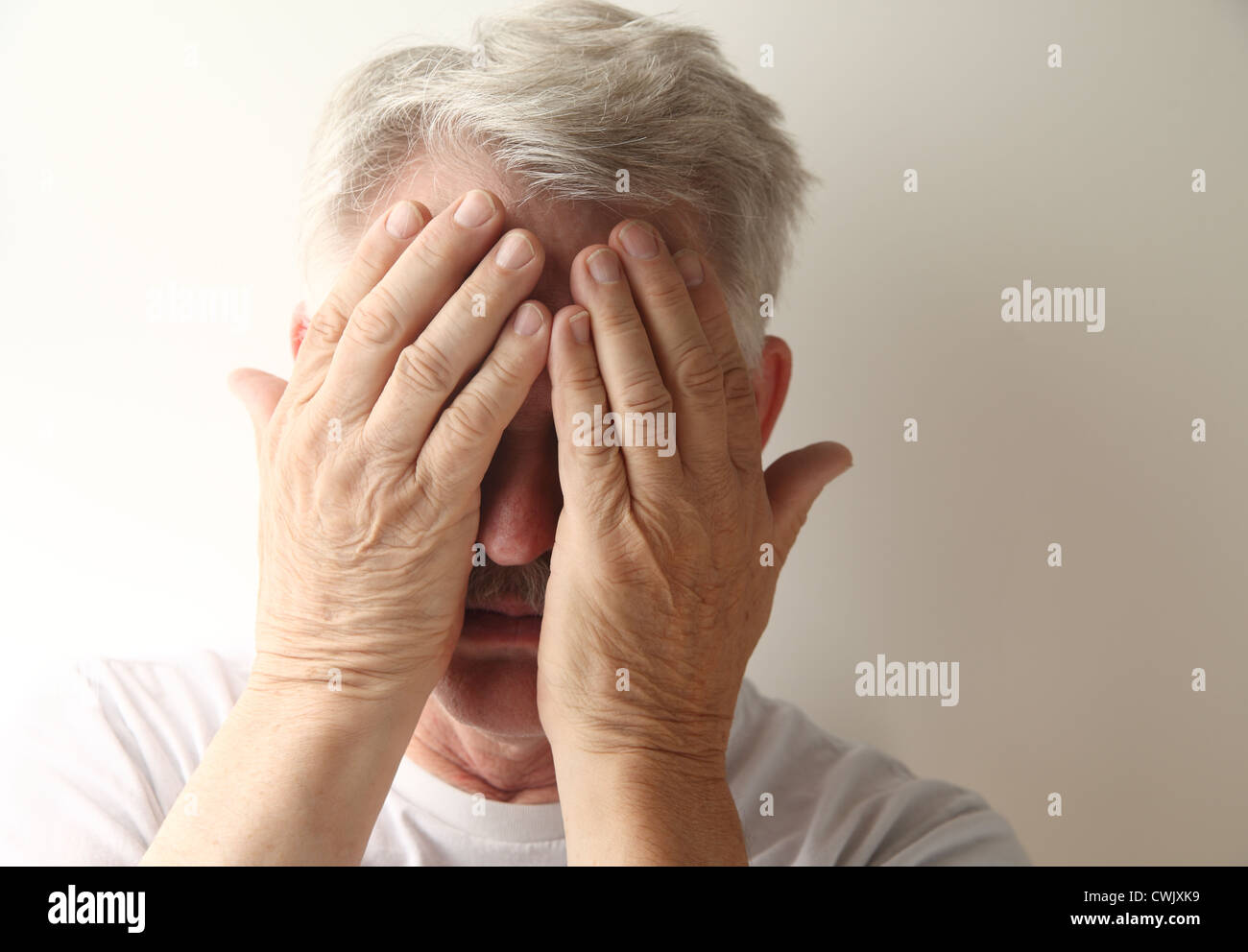 an older man hides his face in embarrassment or grief Stock Photo - Alamy