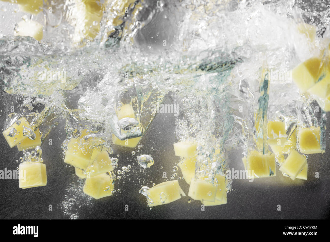 Potato cubes splashing into water Stock Photo - Alamy