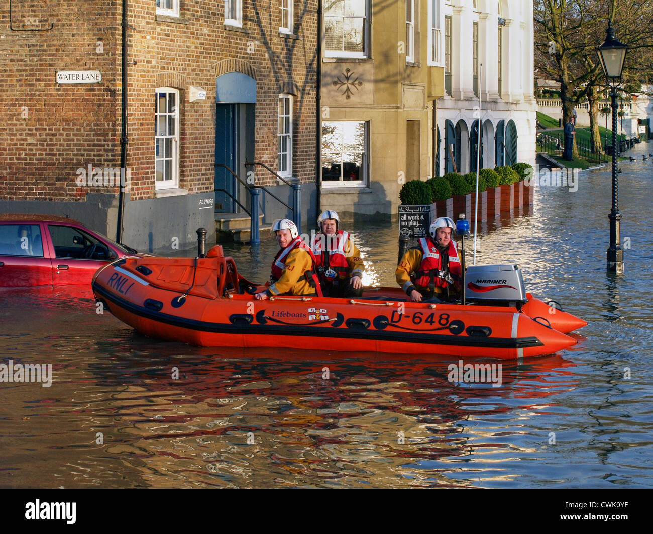Firemen arrive by boat to rescue a stranded motorist as the high tide ...