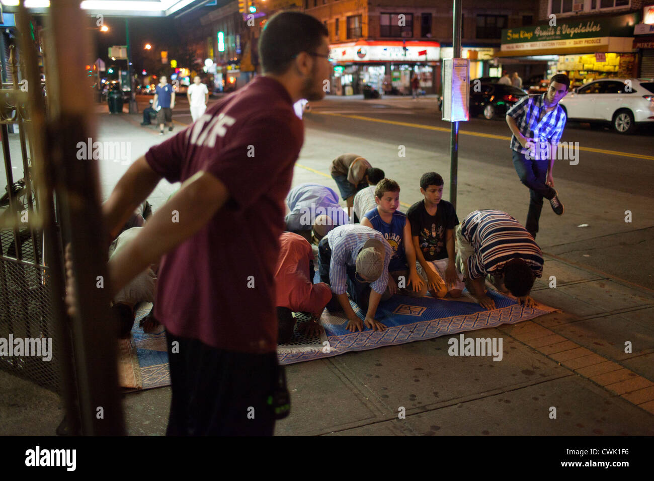 A staff member watches a group of Muslim-American men pray at the ...
