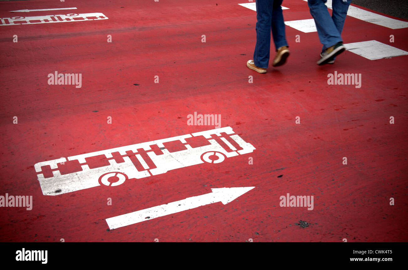Red crosswalk with bus and traffic direction signs Stock Photo - Alamy