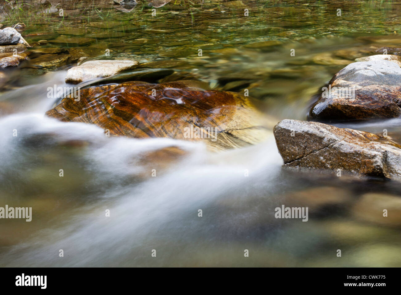 The swift moving water flows along over rocks in this stream Stock ...