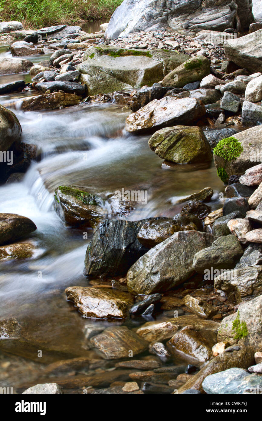 The swift moving water flows along over rocks in this stream Stock ...