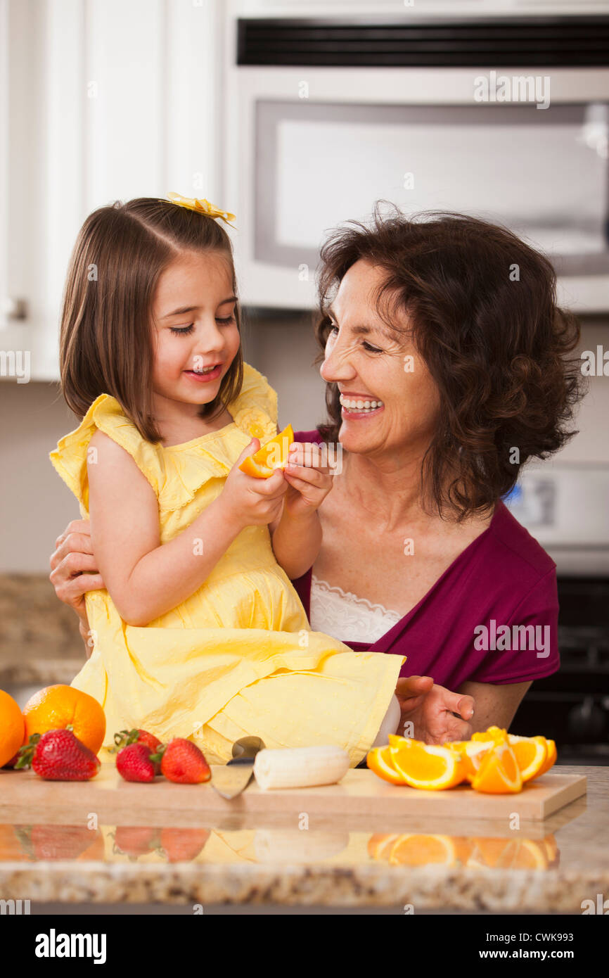 Caucasian grandmother and granddaughter eating fruit Stock Photo - Alamy