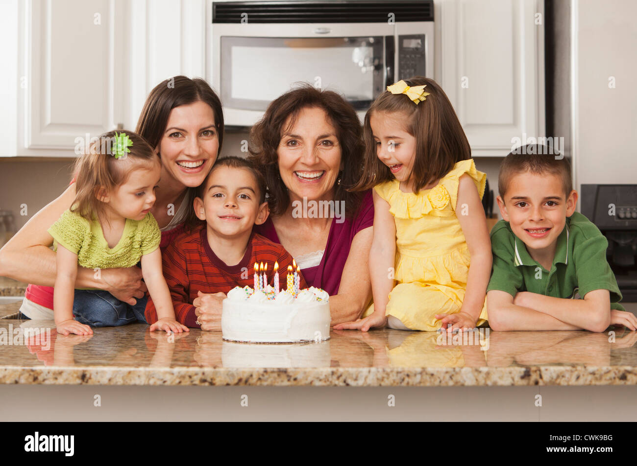 Caucasian family in kitchen with birthday cake Stock Photo - Alamy