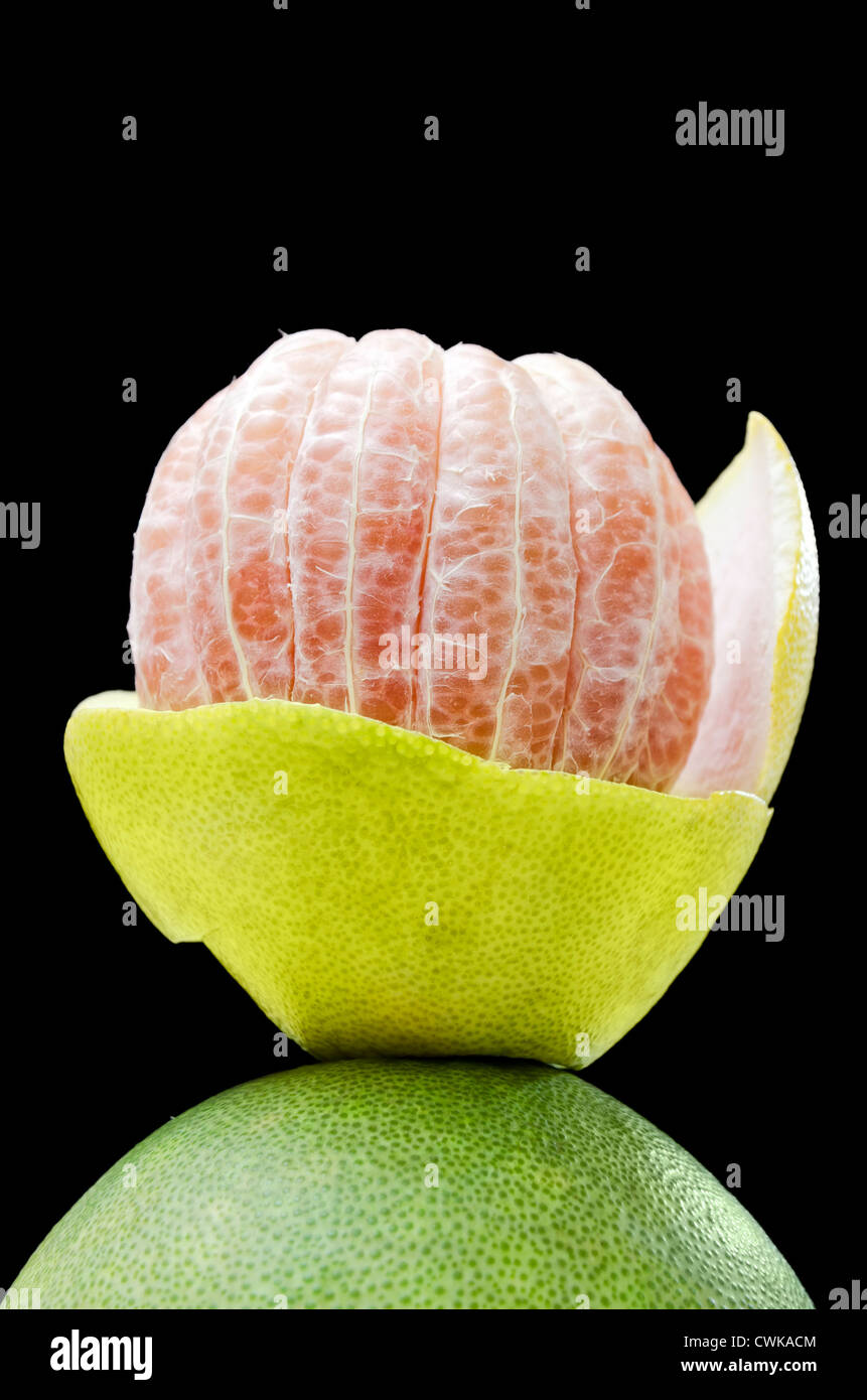 Ripe pomelo with its rind against black background Stock Photo - Alamy