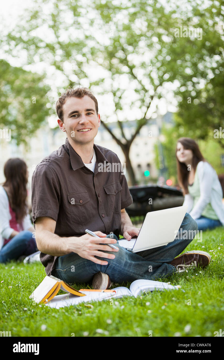 Caucasian man studying in grass Stock Photo - Alamy