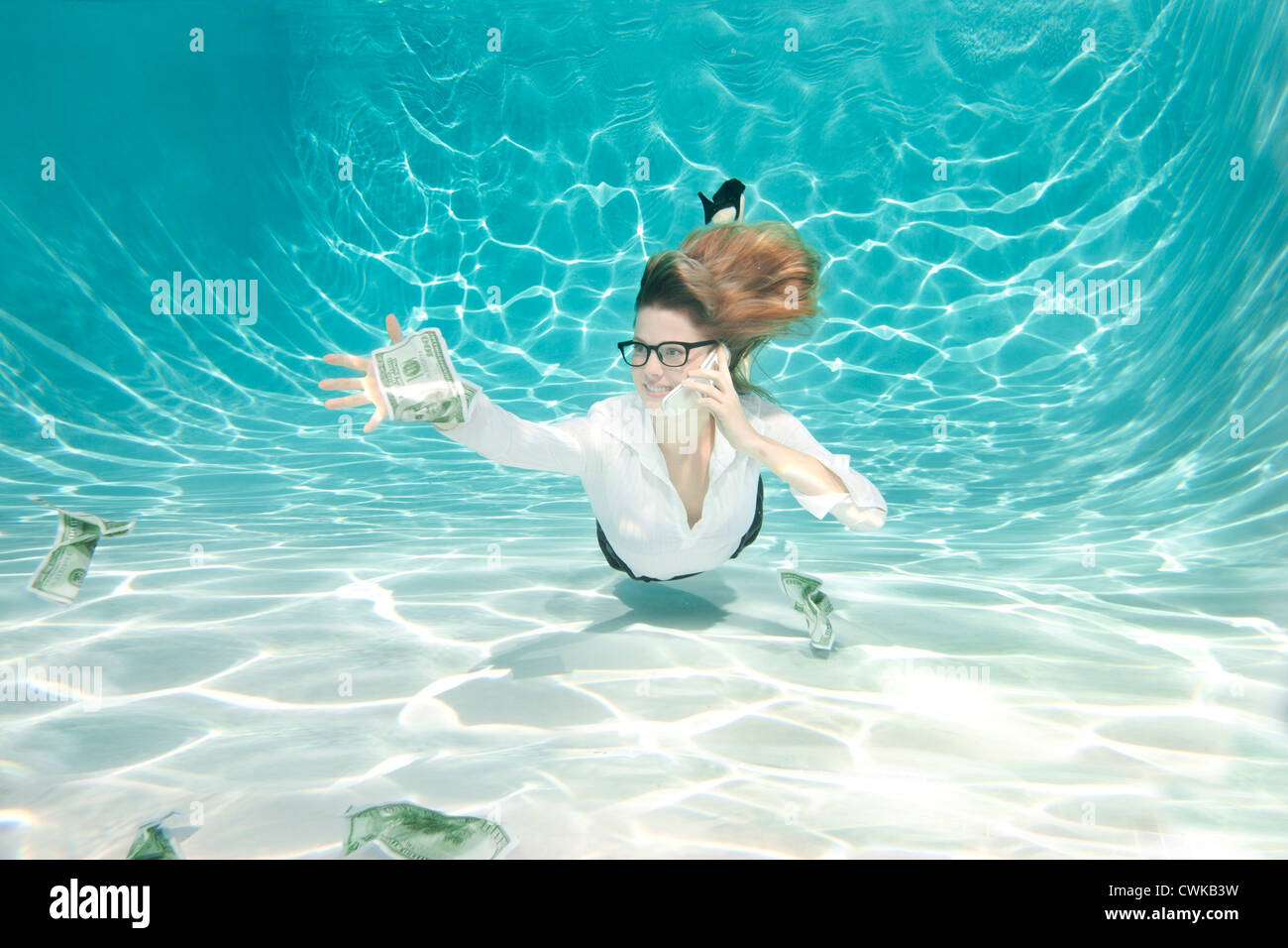 Caucasian businesswoman reaching for money underwater Stock Photo - Alamy