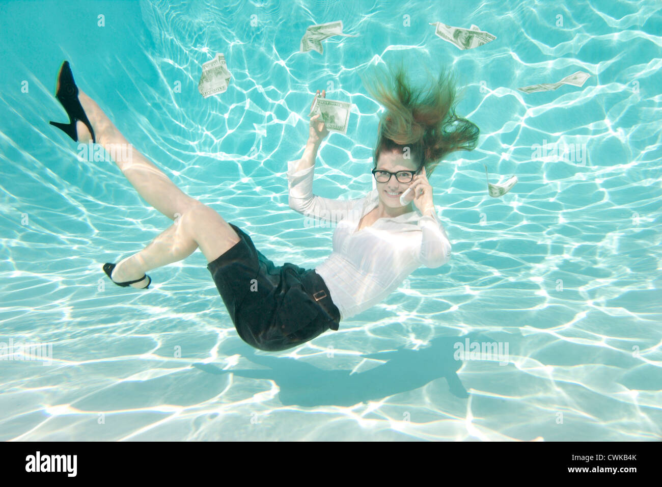 Caucasian businesswoman reaching for money underwater Stock Photo - Alamy