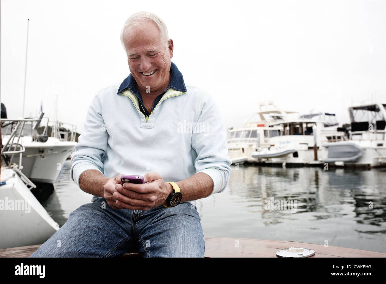 Man using cell phone in marina Stock Photo - Alamy
