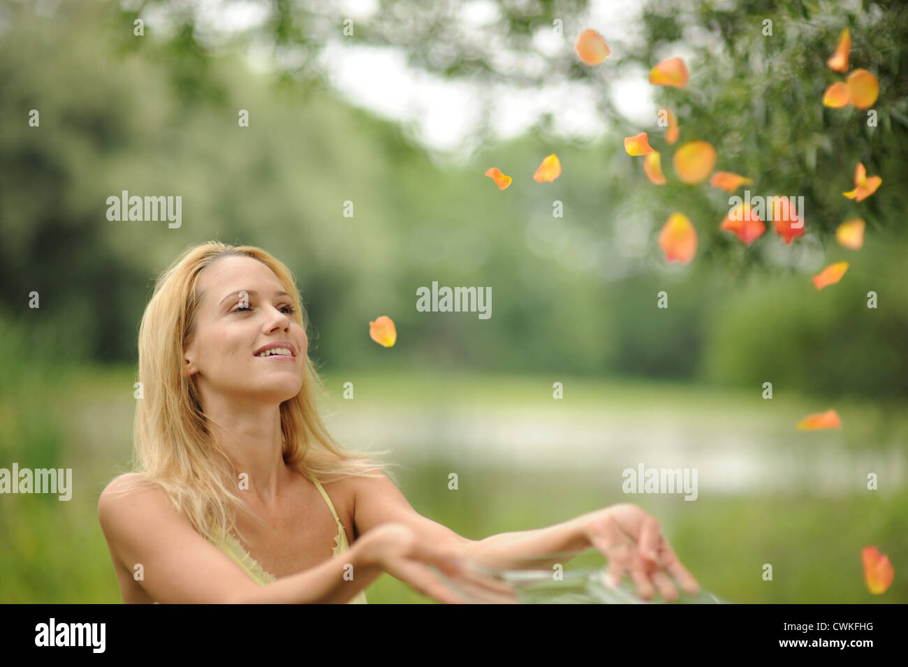 Young Blonde Woman Throwing Rose Leaves Stock Photo - Alamy