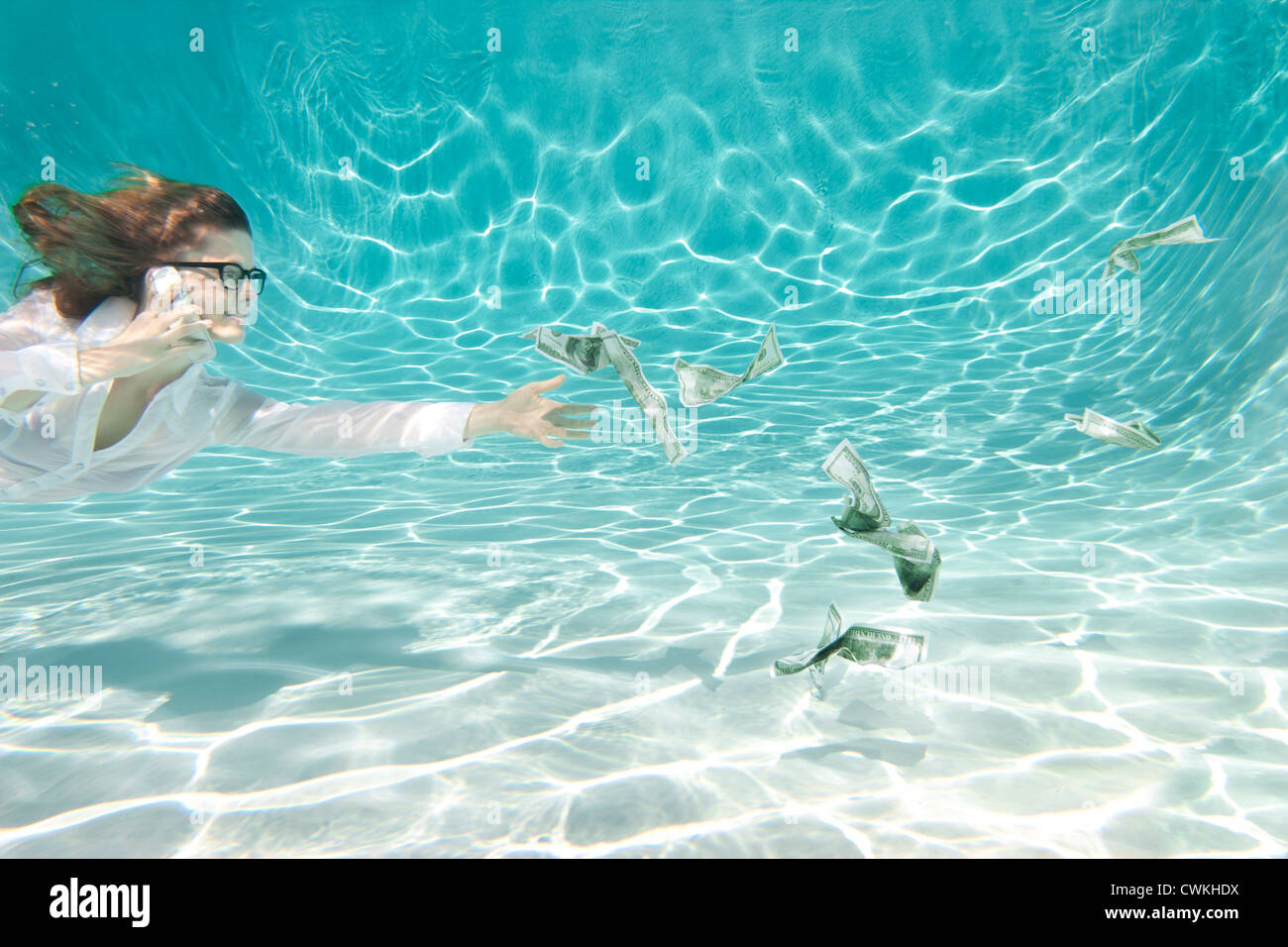 Caucasian businesswoman reaching for money underwater Stock Photo - Alamy