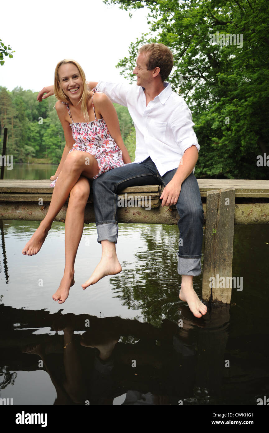two people Sitting on Wooden Bridge Stock Photo - Alamy