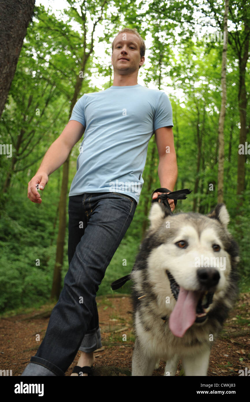 Young Man with a Dog in a Wood Stock Photo - Alamy
