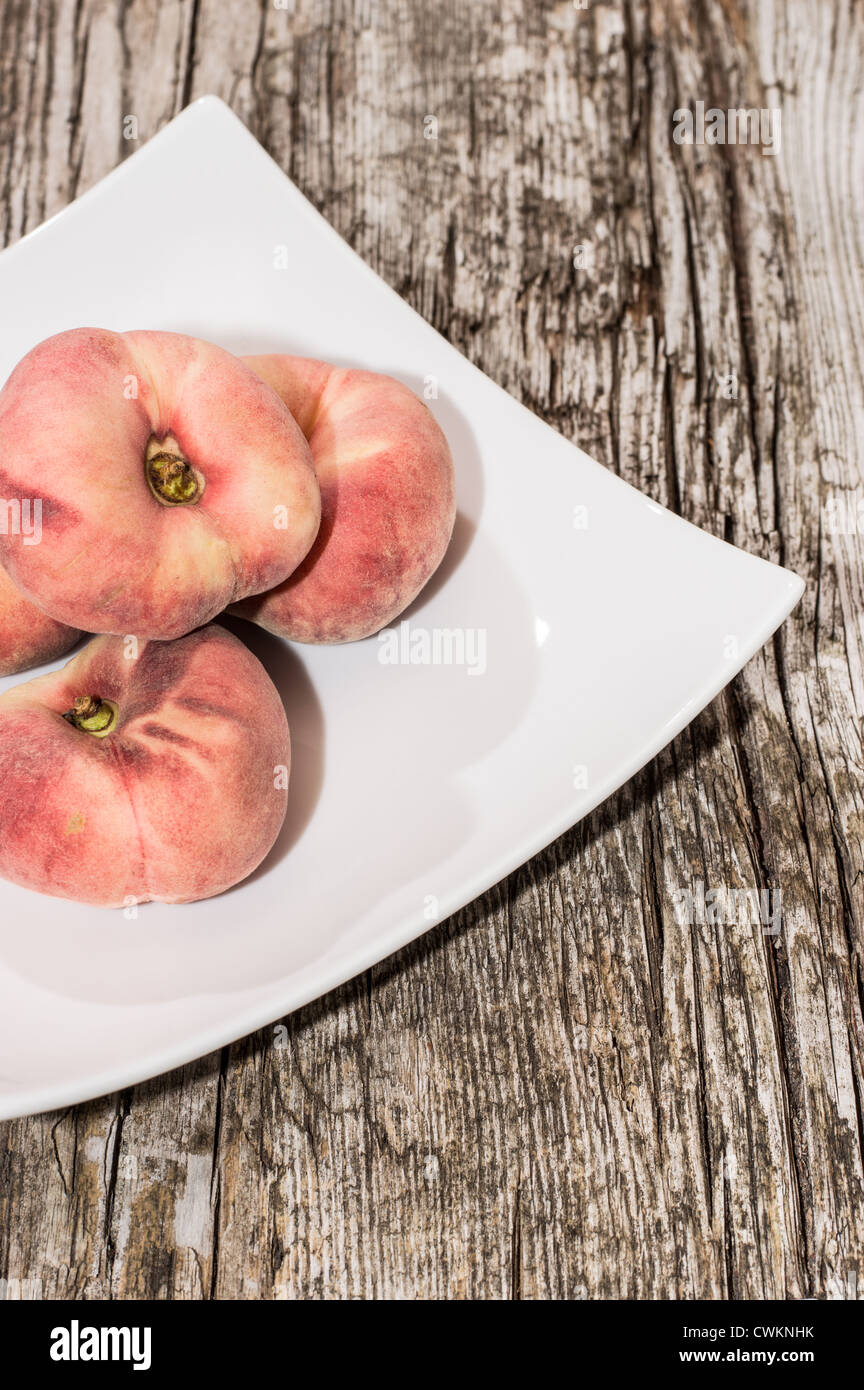 Wild Peaches on a plate on wooden background Stock Photo - Alamy