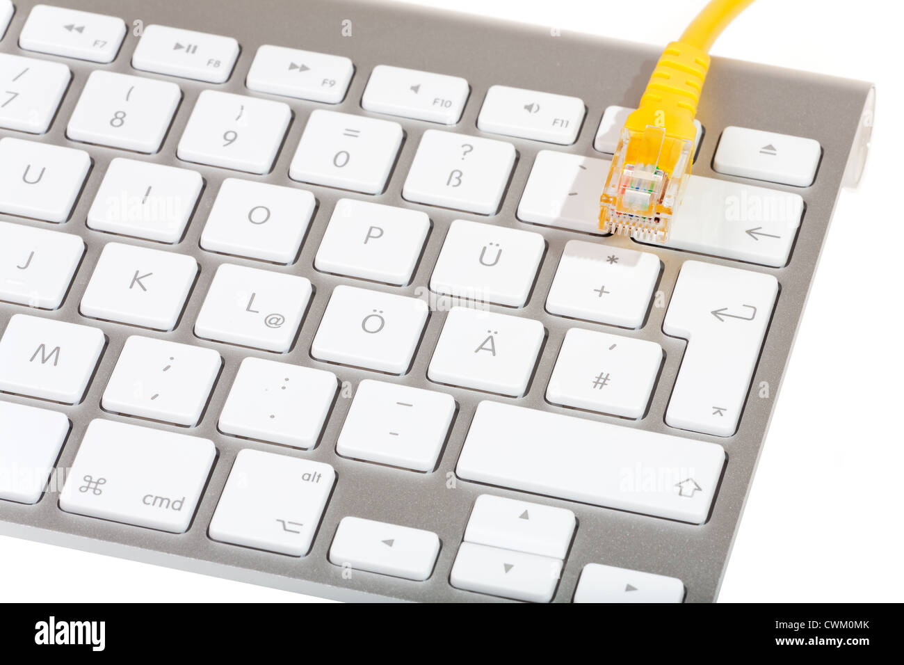 Yellow Network cable on a modern white keyboard isolated on white ...
