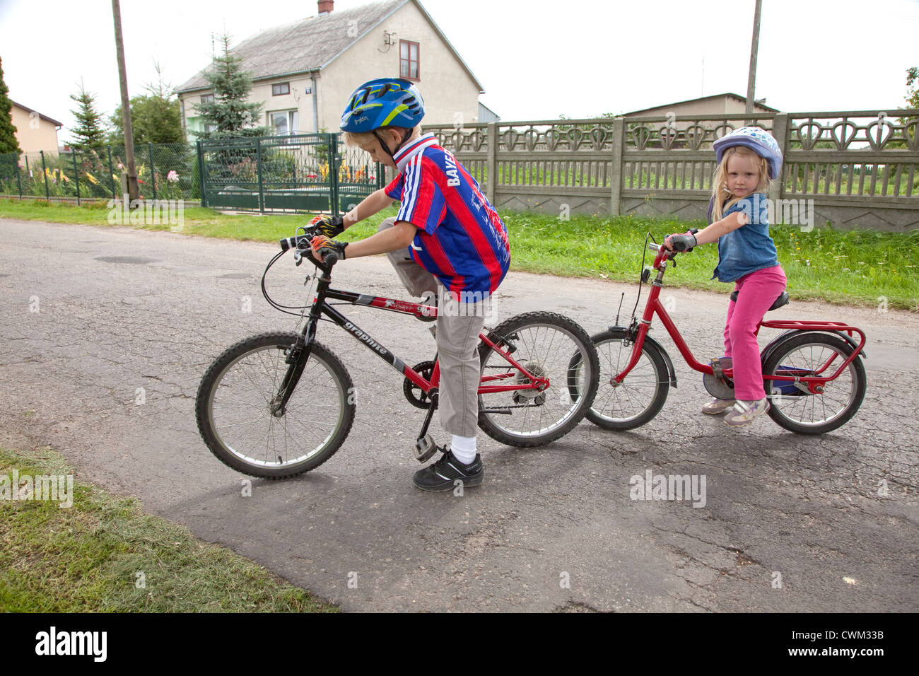 Polish children ages 8 and 4 biking to town wearing helmets. Zawady ...
