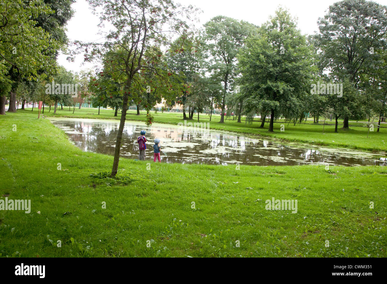 Polish children playing by city pond. Paderewski Park Rzeczyca Central ...