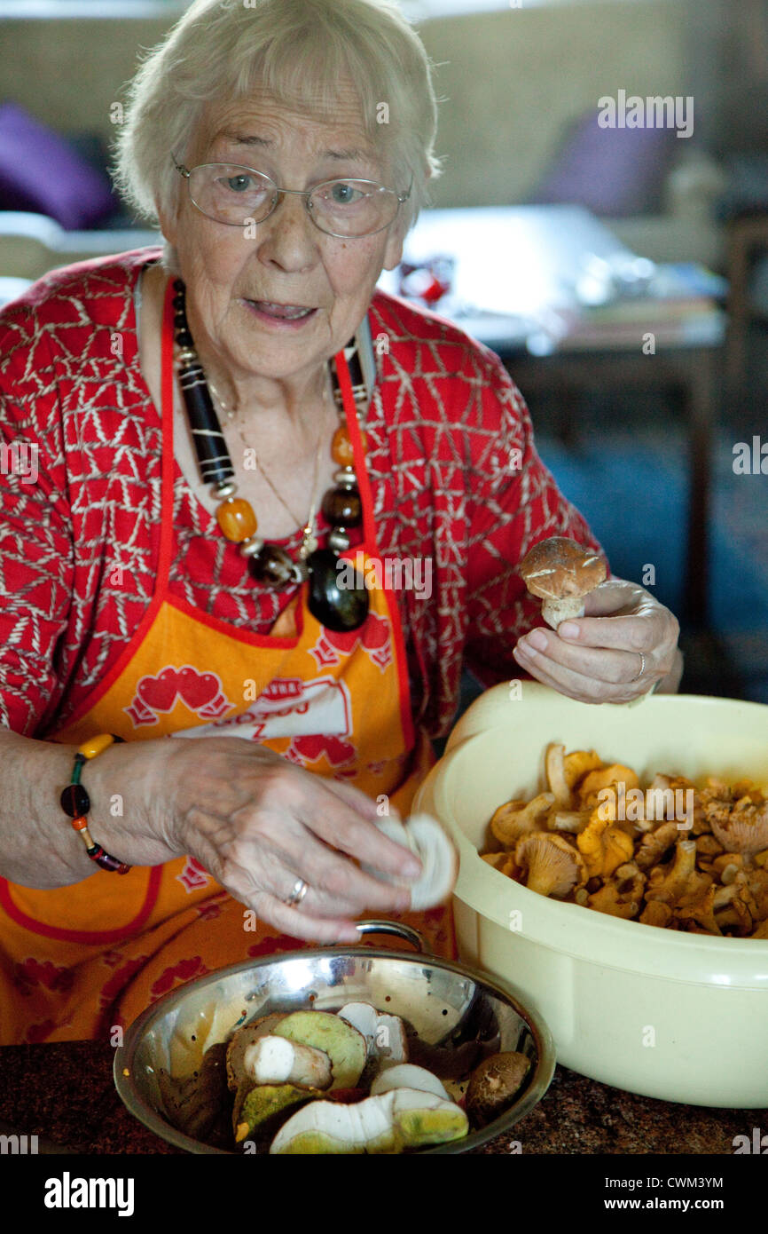 Polish woman age 86 preparing mushrooms (grzyby) for the evening dinner ...