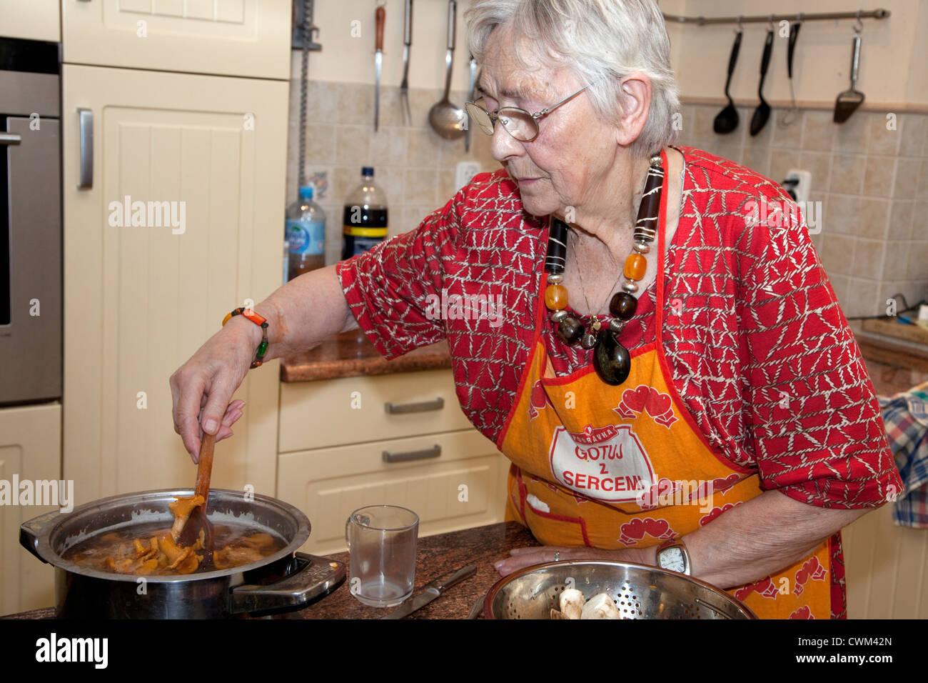 Mature woman cooking home in hi-res stock photography and images - Alamy