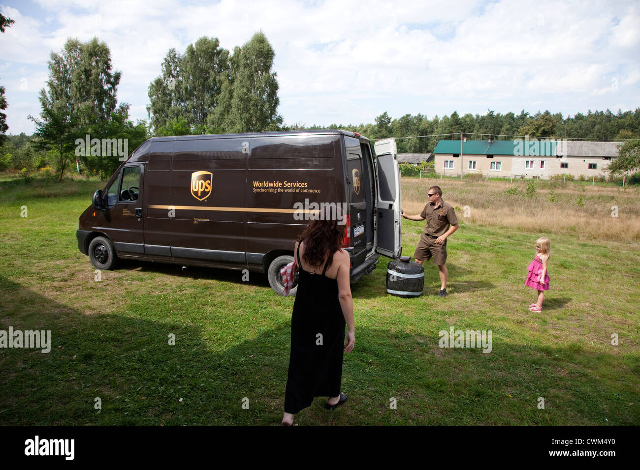 UPS delivery man unloading package for business in the home ...