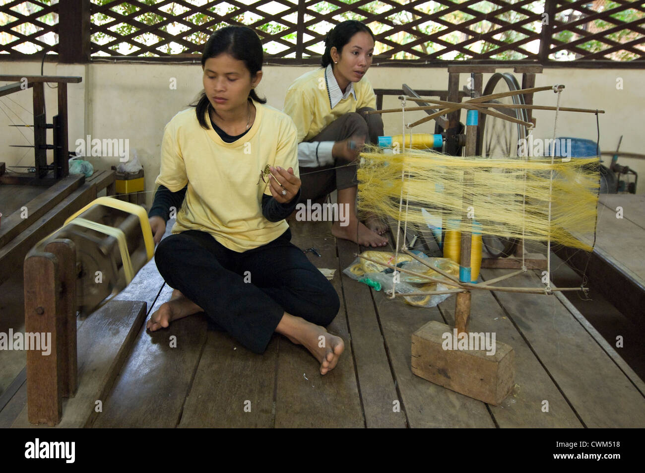Horizontal close up of women spinning silk into threads ready for use ...