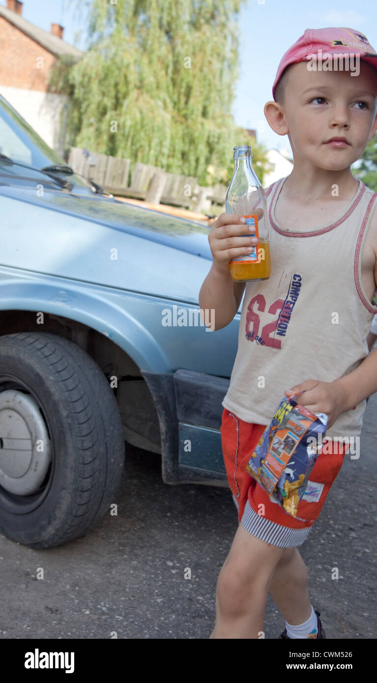 Polish child age 7 carrying his pop and chips from the village grocery ...