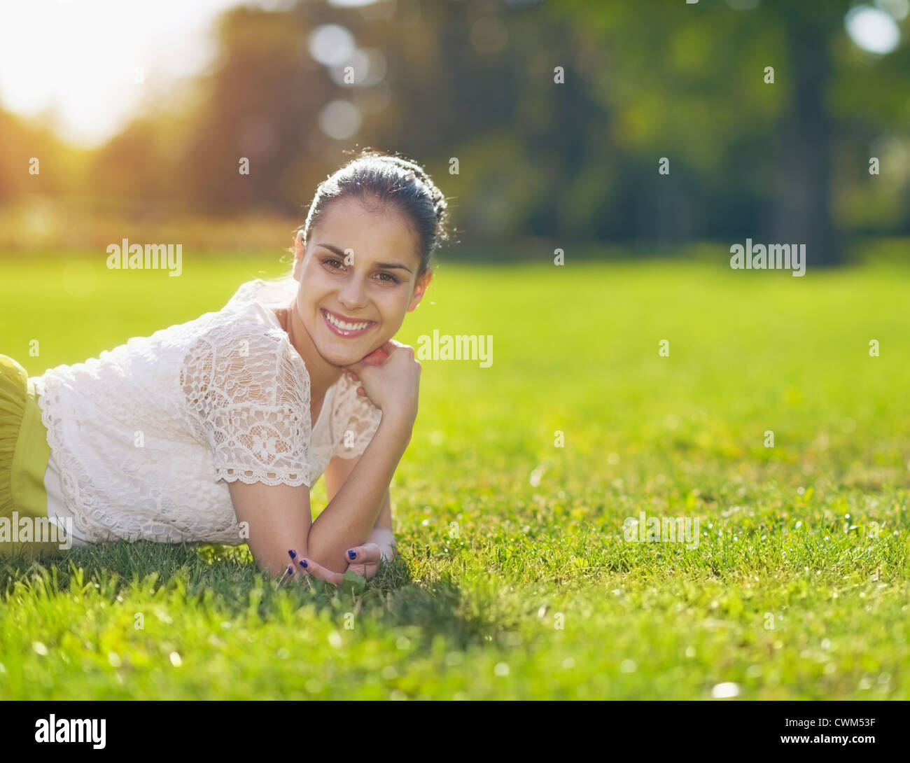 Portrait of smiling girl laying on meadow Stock Photo - Alamy