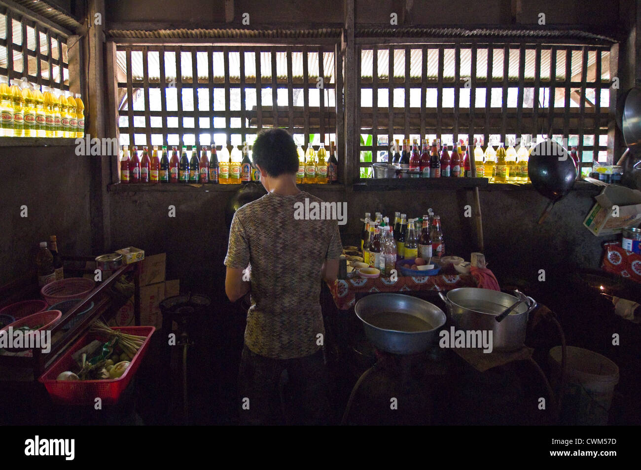 Horizontal close up of a male chef cooking in a basic kitchen with ...