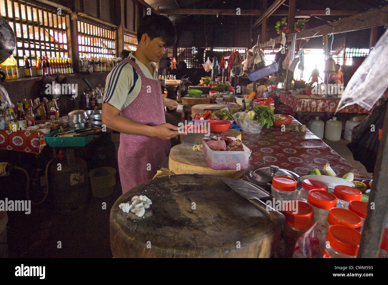 Horizontal close up of a male chef cooking in a basic kitchen with ...