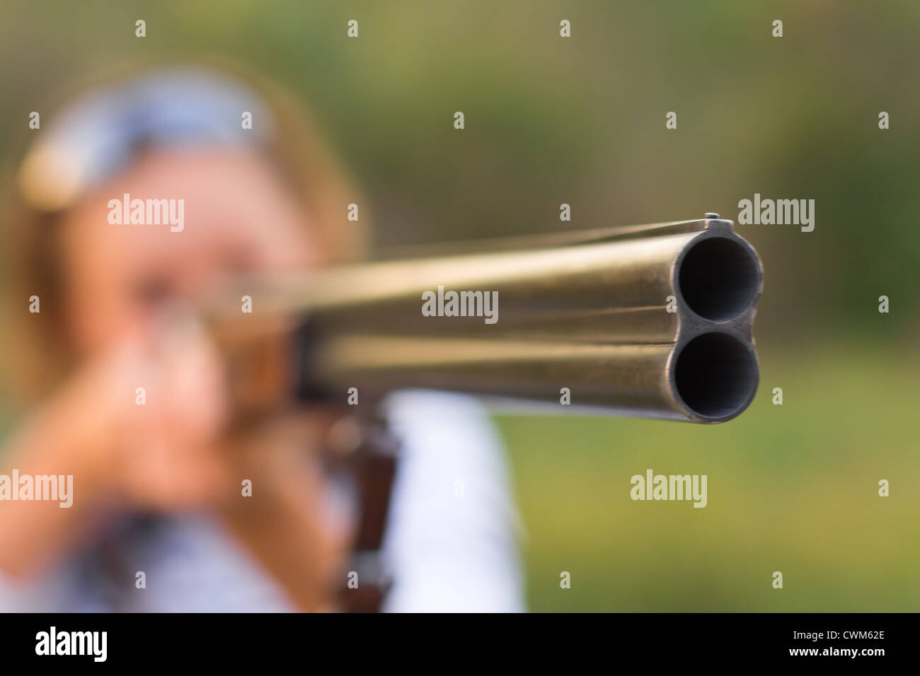 A young girl with a gun and shooting glasses. Short depth of field ...