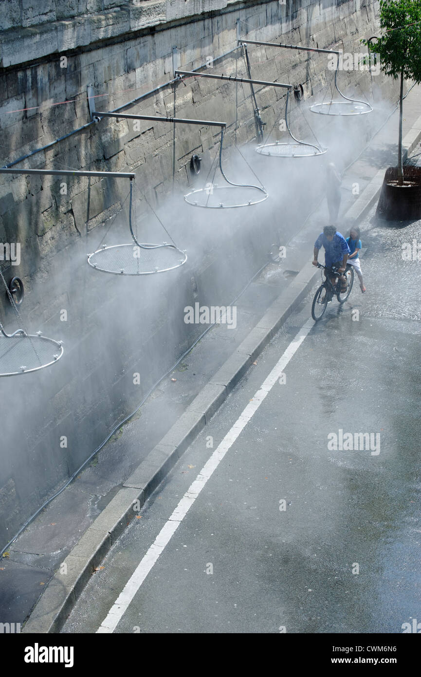 Young boys cycling through cooling showers in the heat of the Paris ...