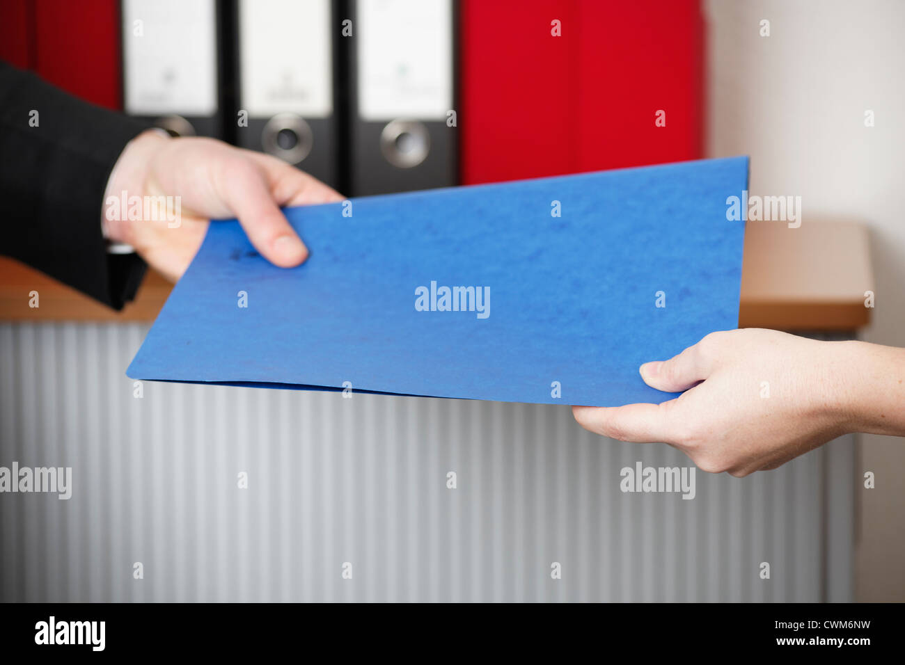 Germany, Businessman giving file to businesswoman Stock Photo - Alamy