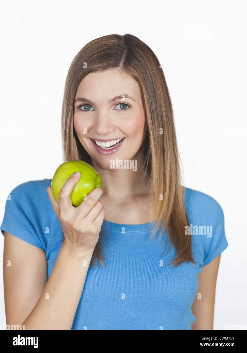Young woman holding apple, smiling, portrait Stock Photo - Alamy