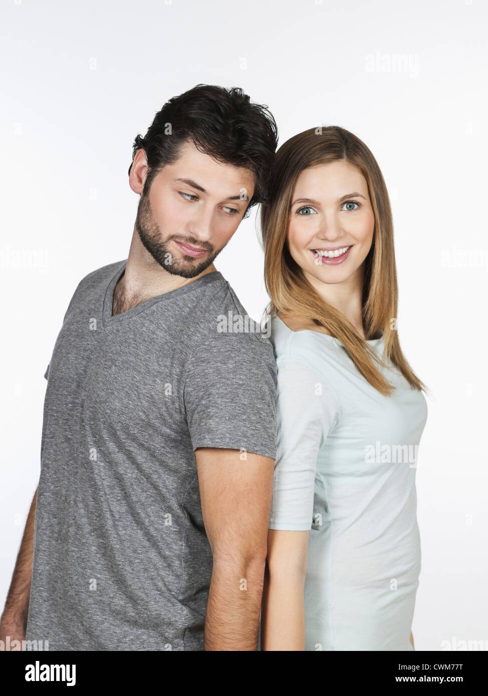 Young couple standing back to back Stock Photo - Alamy