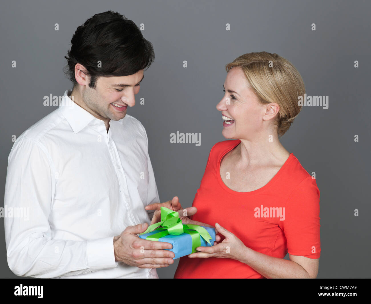 Man giving gift to woman, smiling Stock Photo - Alamy