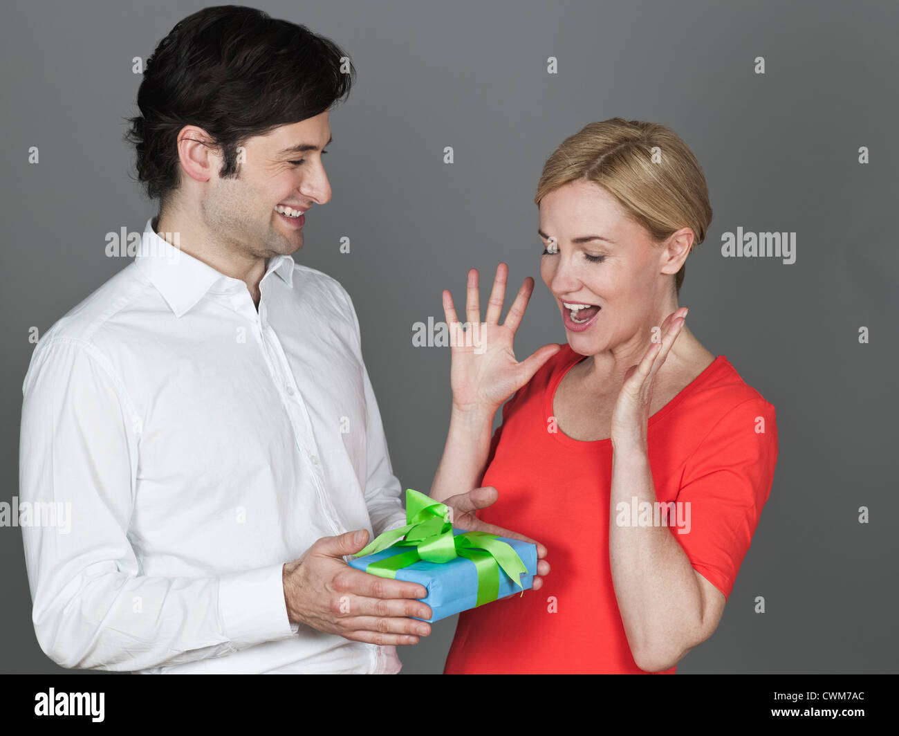Man giving gift to woman, smiling Stock Photo - Alamy