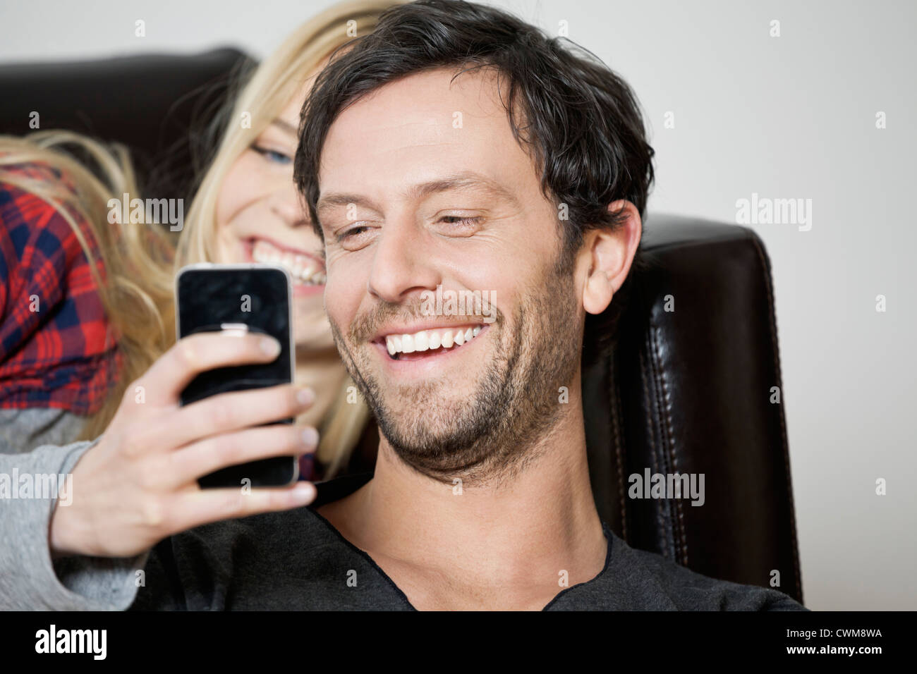 Couple watching cell phone, smiling, close up Stock Photo - Alamy