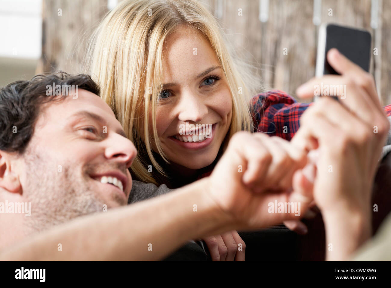 Couple watching cell phone, smiling, close up Stock Photo - Alamy