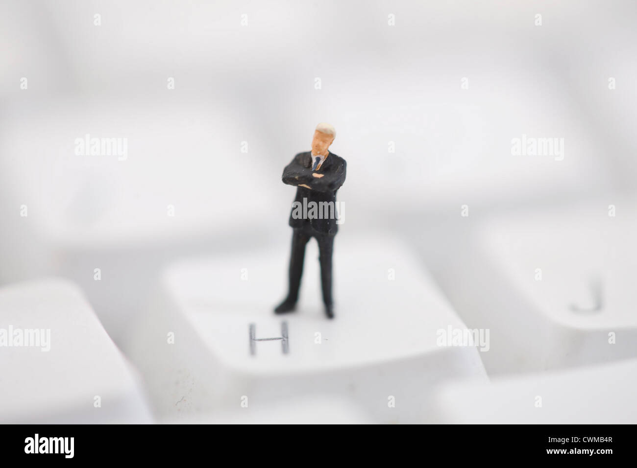 Figurine standing on computer keyboard Stock Photo - Alamy