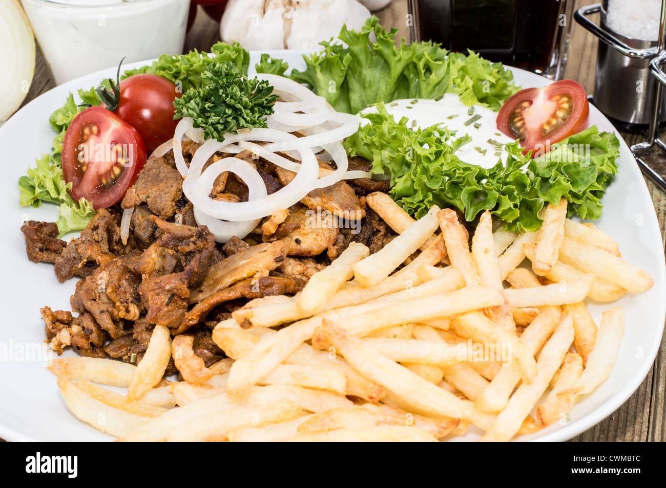 Portion of Kebab meat on a plate on wooden background Stock Photo - Alamy