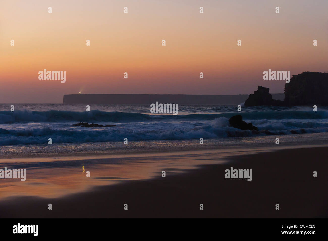 Portugal, Algarve, Sagres, View of beach with breaking waves at sunset ...
