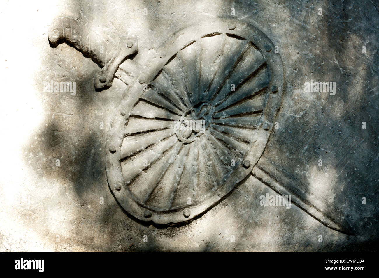 Old tombstone on cemetery with sword and shield Stock Photo - Alamy