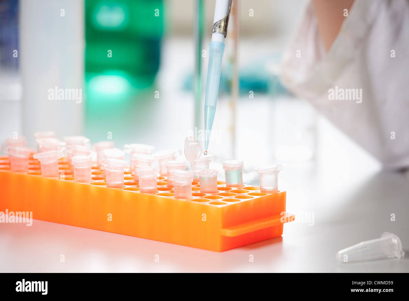 Germany, Bavaria, Munich, Scientist filling test tubes with pipette for ...