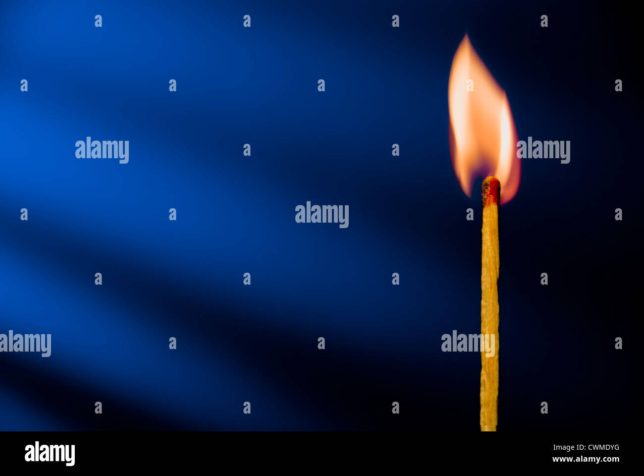 Flame of matchstick against blue background Stock Photo - Alamy