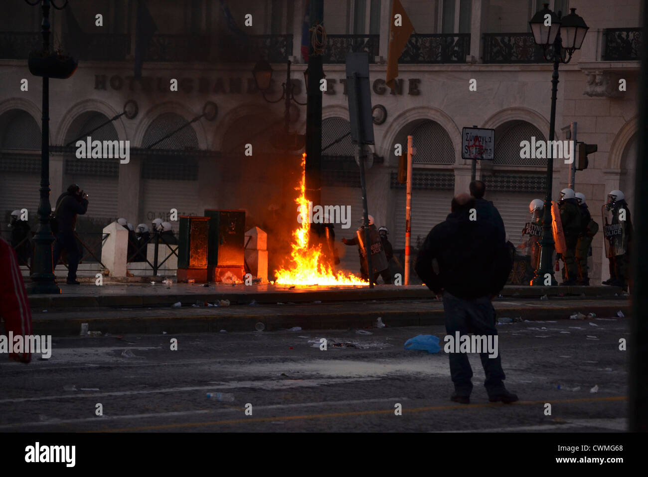 Petrol bombs burn next to riot police during an anti-austerity ...