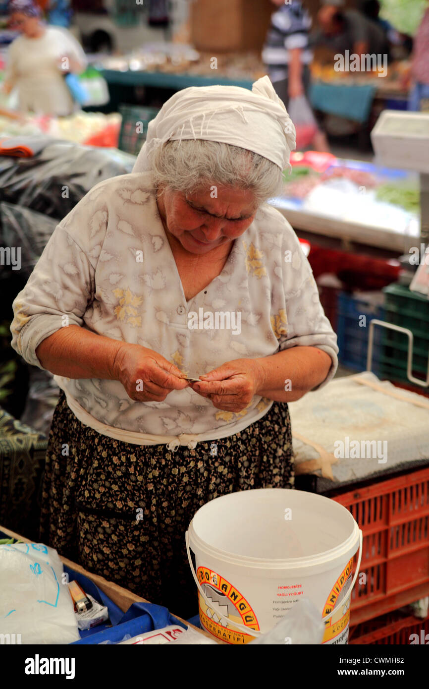 Elderly Turkish woman closely checks her change in a market near Dalyan ...